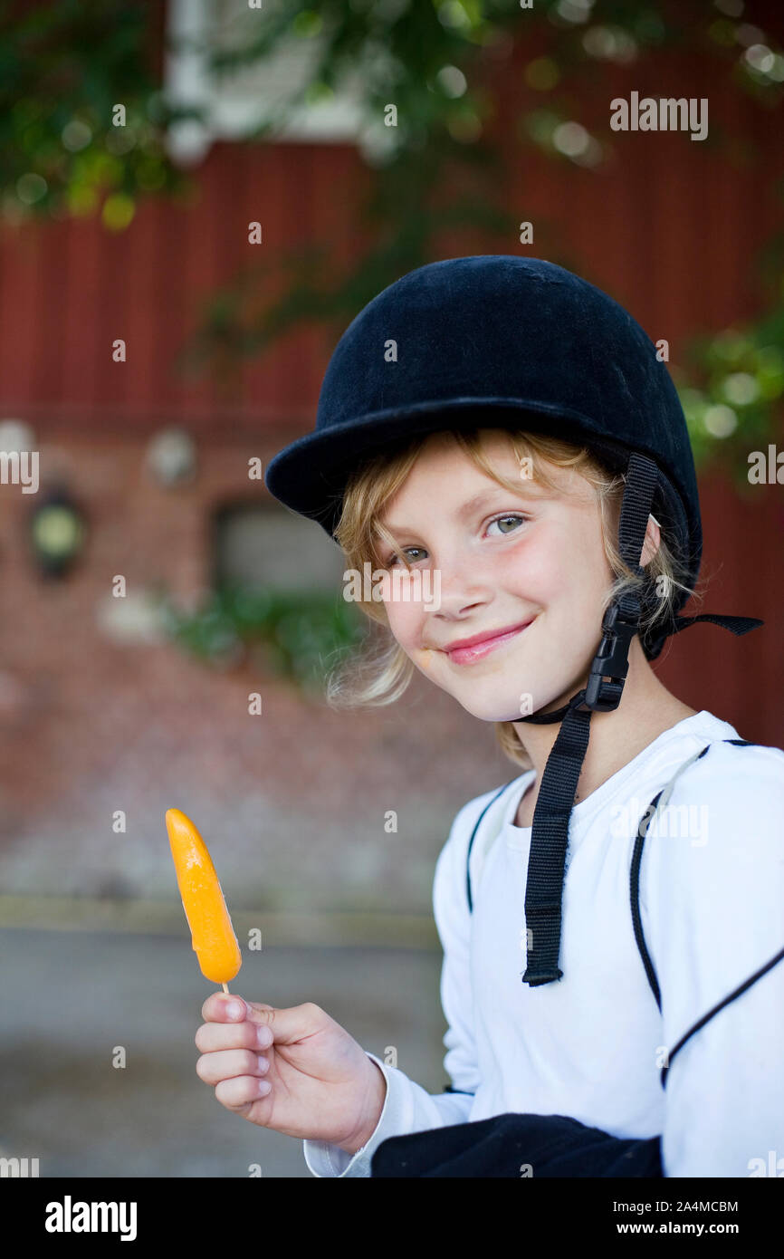 Girl with riding helmet and ice cream Stock Photo - Alamy