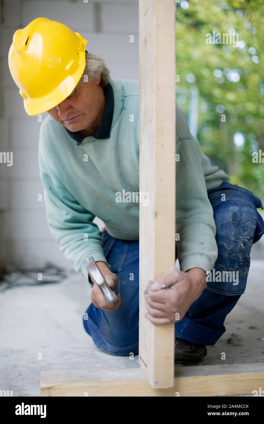 Builder wearing yellow hard hat Stock Photo - Alamy
