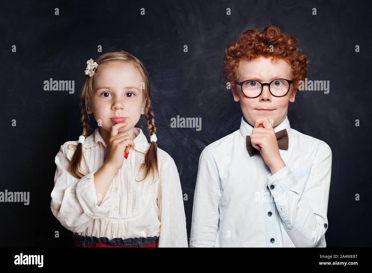 Two thinking kids on blackboard portrait Stock Photo - Alamy