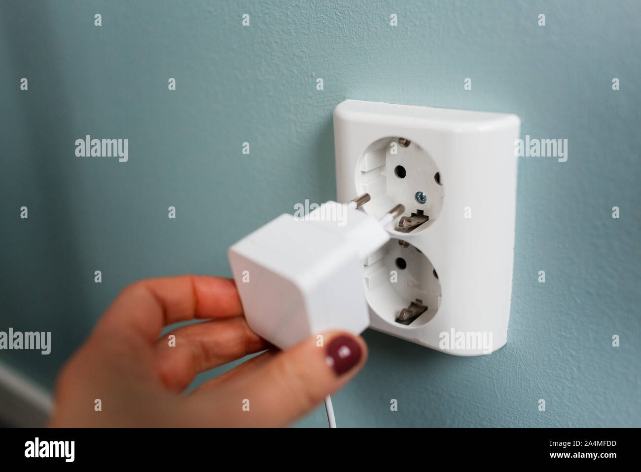 Woman holding plug Stock Photo - Alamy