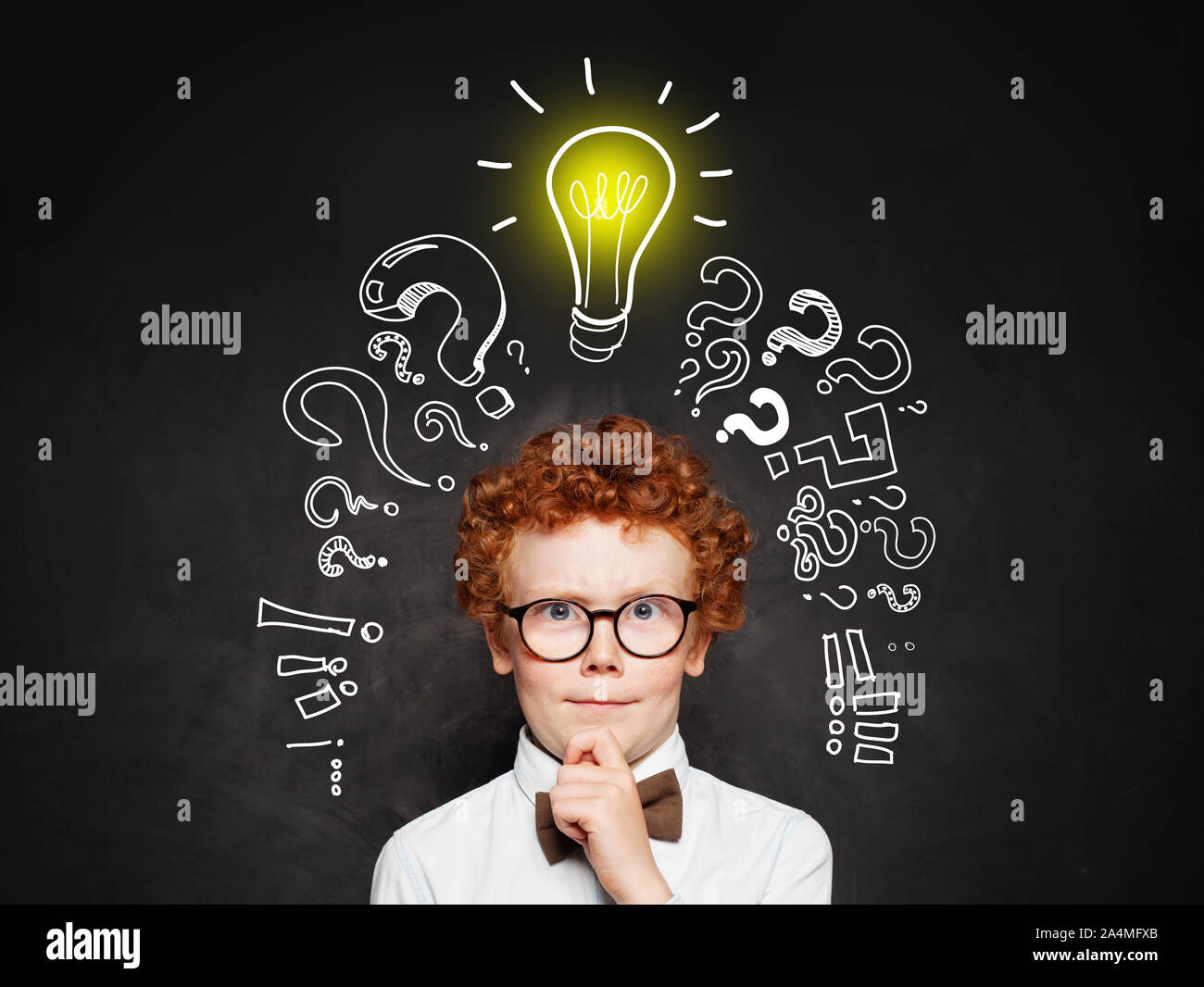 Idea concept. Cute young boy student with question marks and light bulb ...