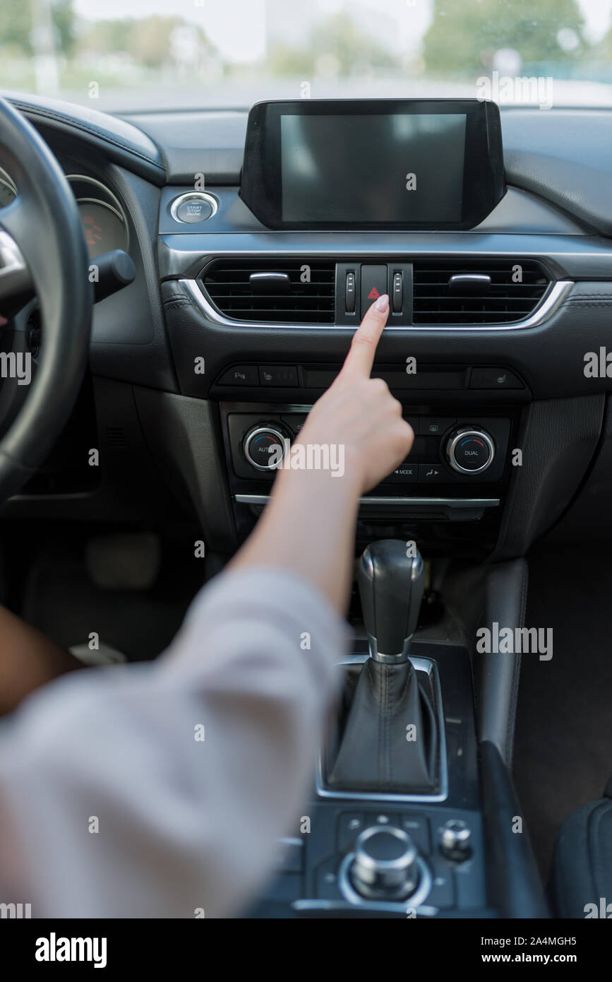 woman wheel of car presses emergency stop button, activating signal ...