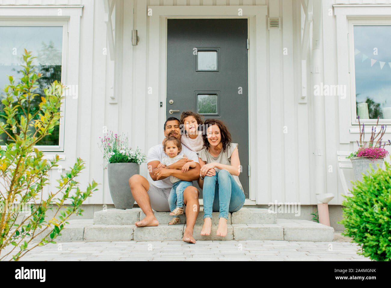 Family sitting on front stoop Stock Photo - Alamy