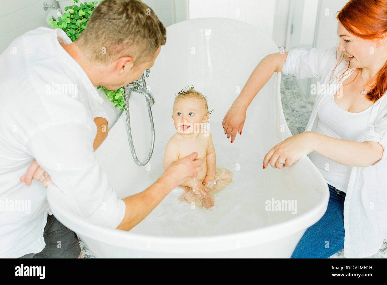 Parents with baby in bath Stock Photo - Alamy