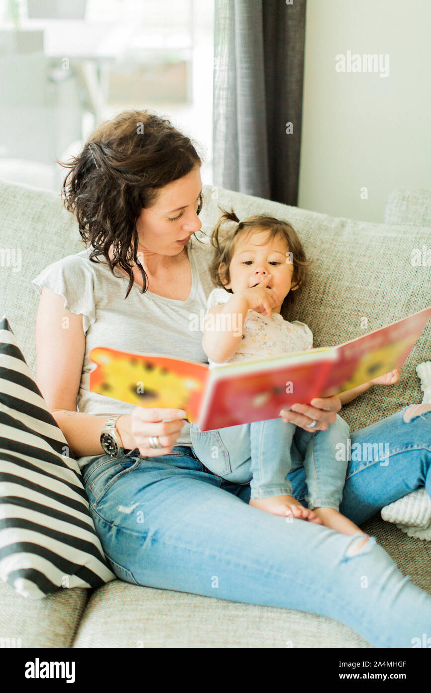 Mother reading childrens book with daughter Stock Photo - Alamy