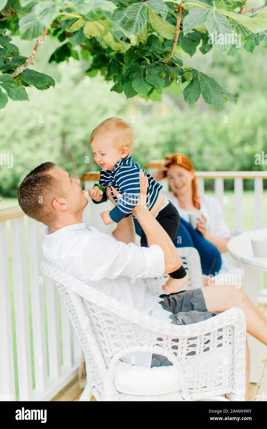 Parents with baby boy resting on balcony Stock Photo - Alamy