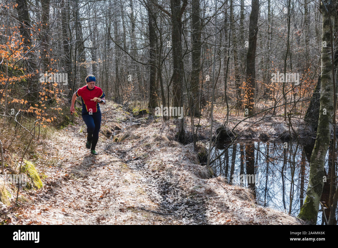 Woman running through forest Stock Photo - Alamy