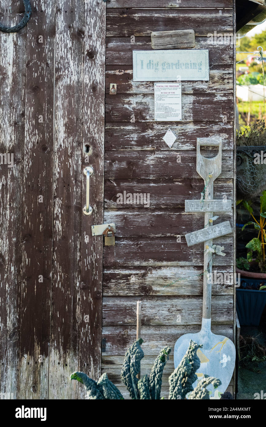A quirky weathered garden shed with an old fashioned spade and slogans ...