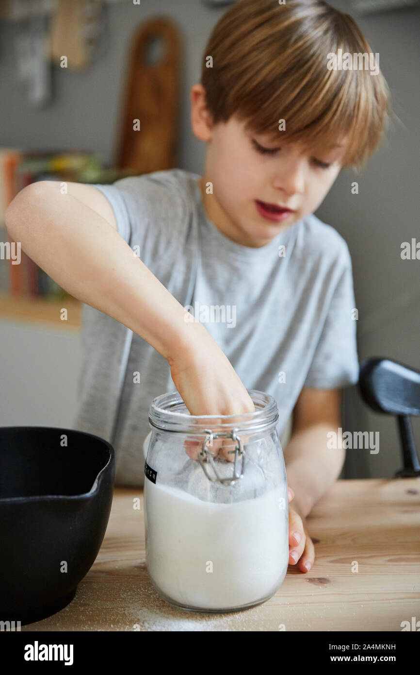 Boy reaching into jar Stock Photo - Alamy