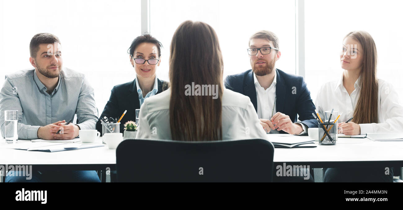 Woman at job interview talking with members of management Stock Photo ...