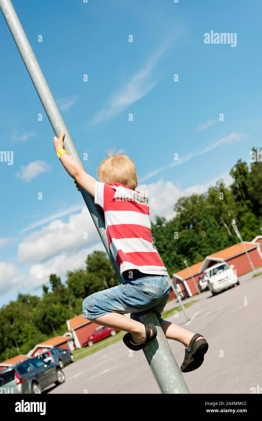 Boy climbing pole Stock Photo - Alamy
