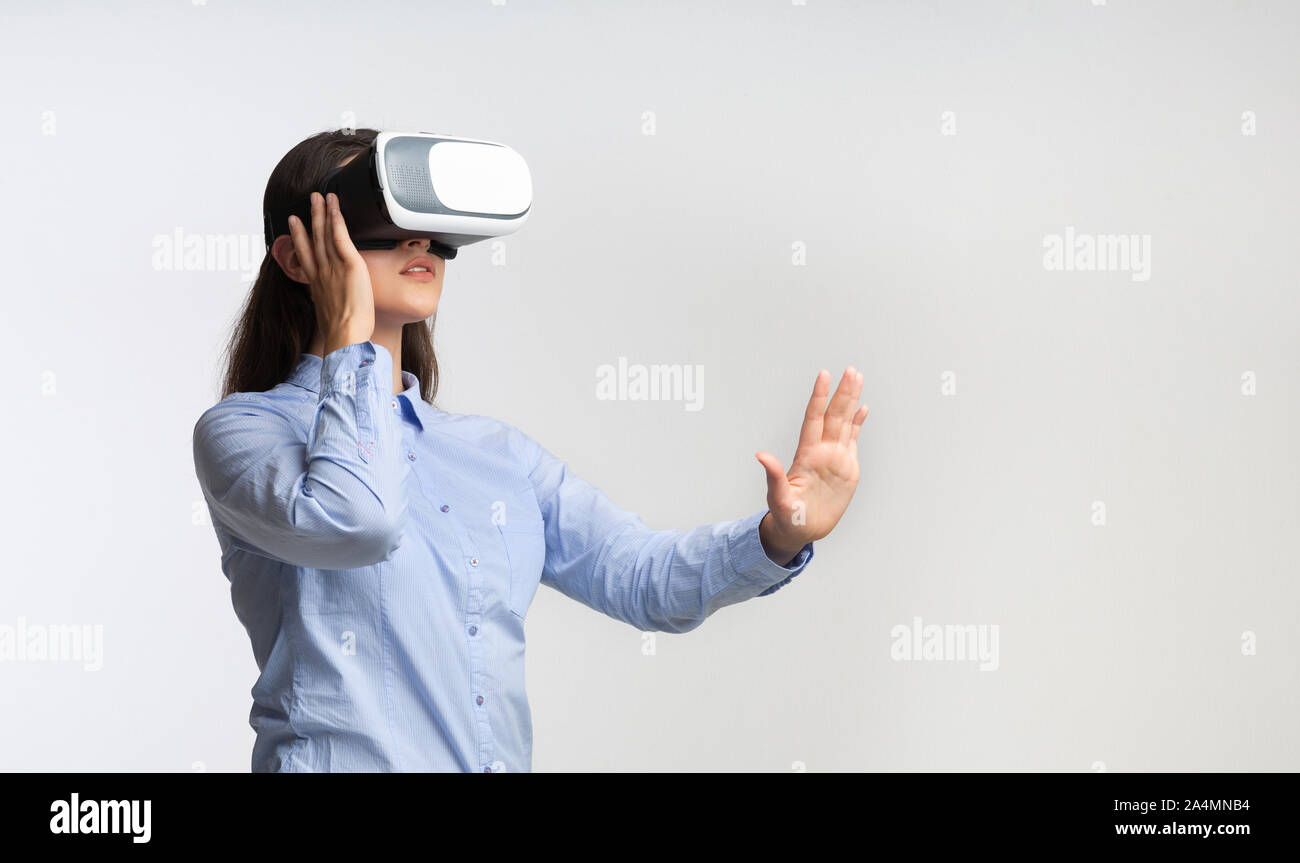 Millennial Girl Wearing Virtual Reality Headset Standing In Studio ...