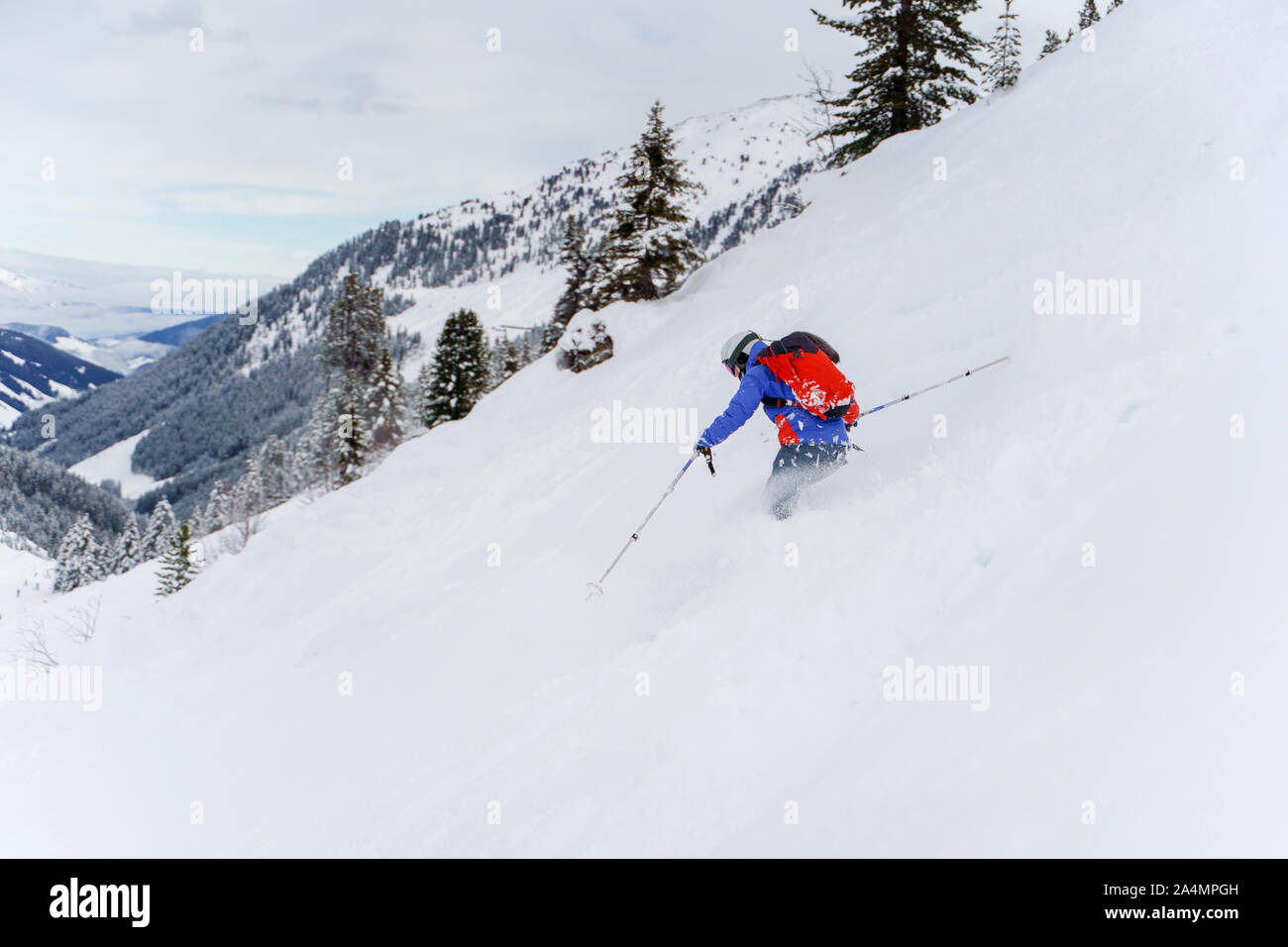 Photo from back of athlete man with red backpack skiing in winter ...