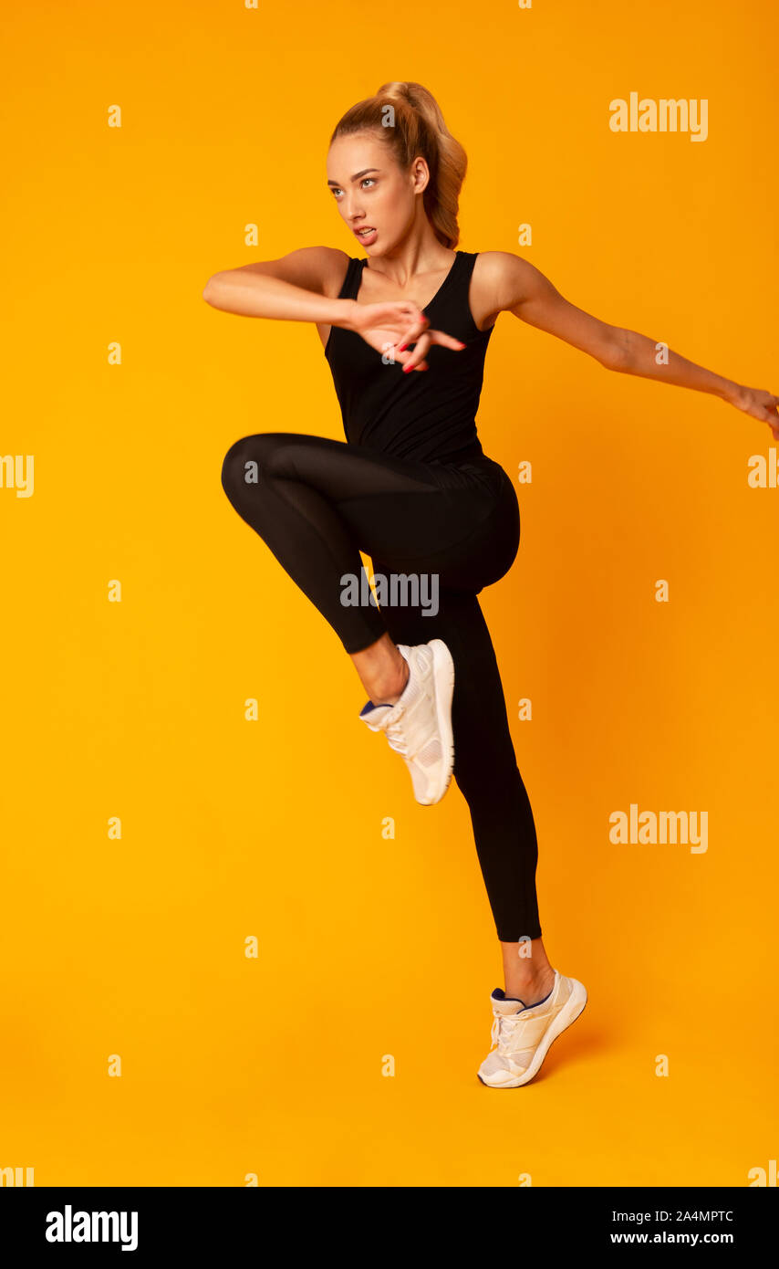 Sporty Lady Jumping Exercising In Studio Over Yellow Background Stock ...