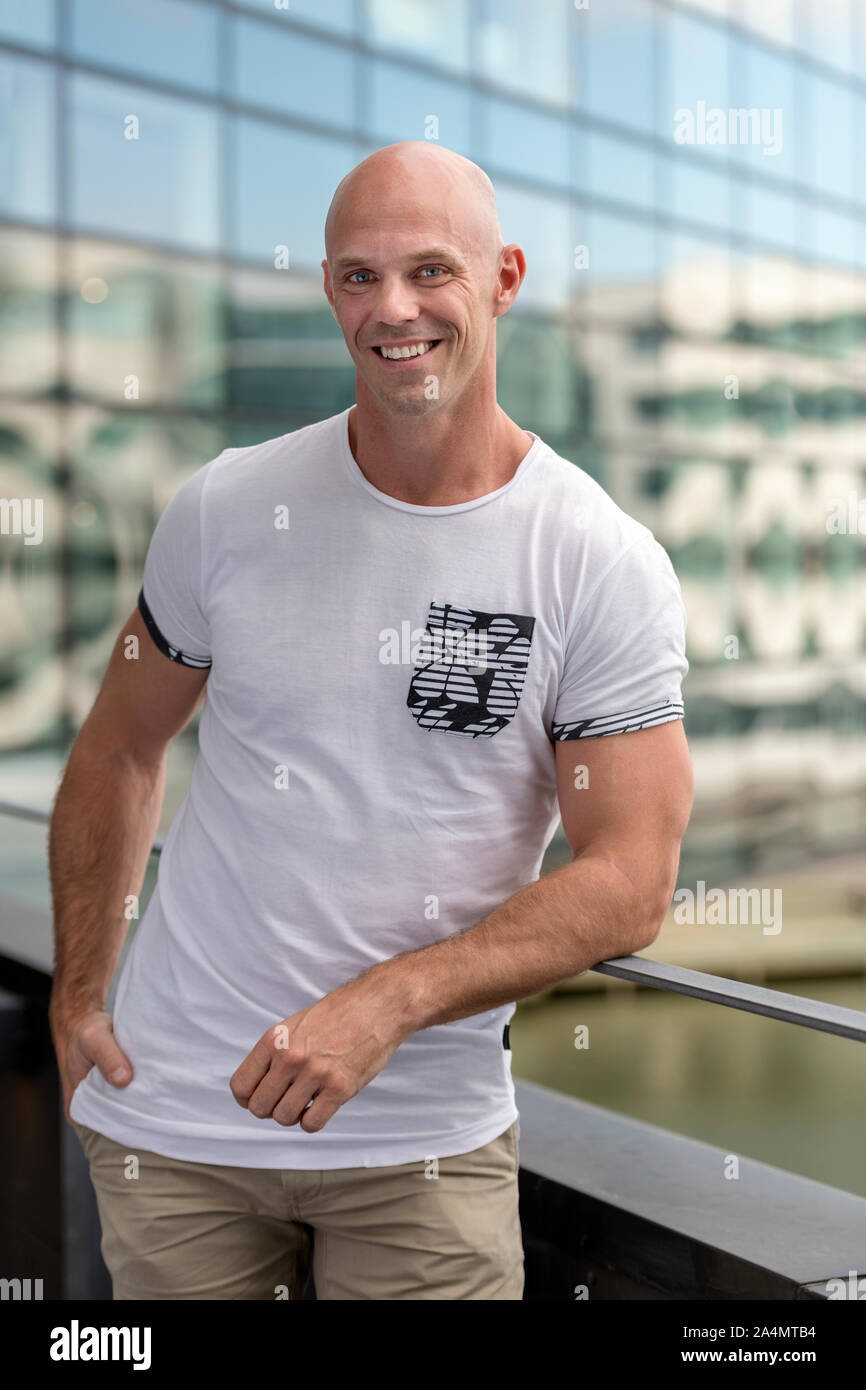 Smiling man standing on balcony Stock Photo - Alamy