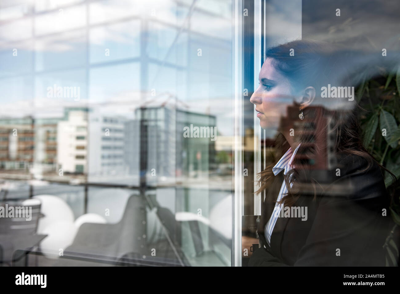 Woman looking through window Stock Photo - Alamy