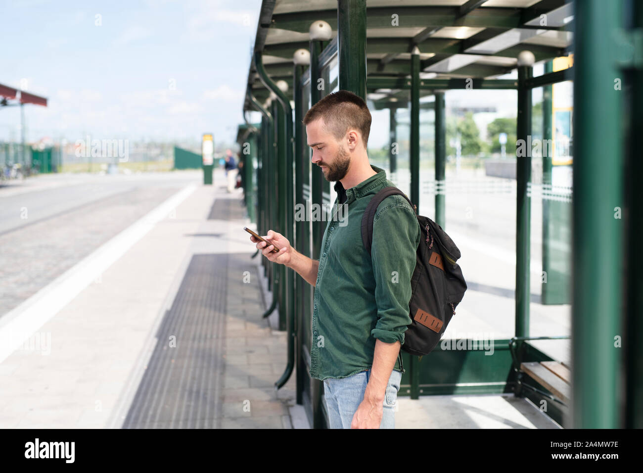 Man waiting on bus stop Stock Photo - Alamy