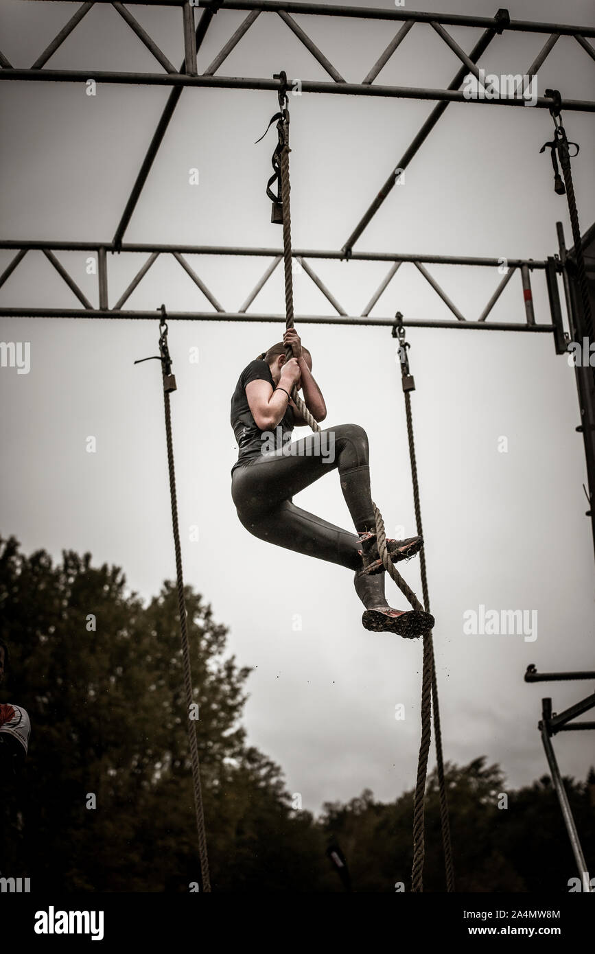 Woman climbing rope Stock Photo - Alamy