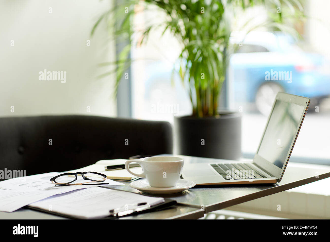 Image of laptop computer documents and cup of coffee are on the table ...