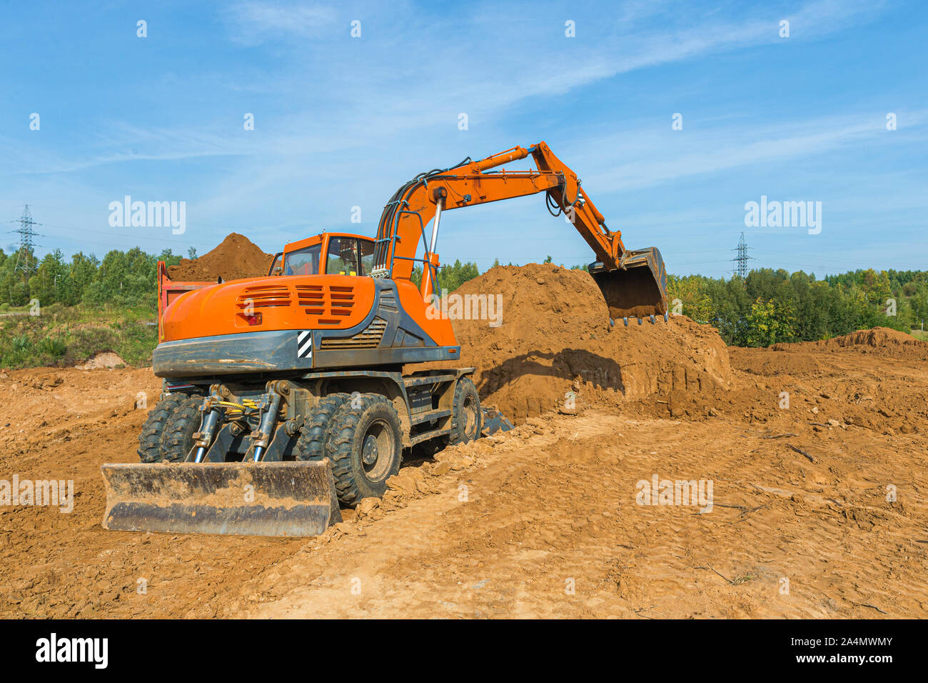 The modern excavator performs excavation work on the construction site ...