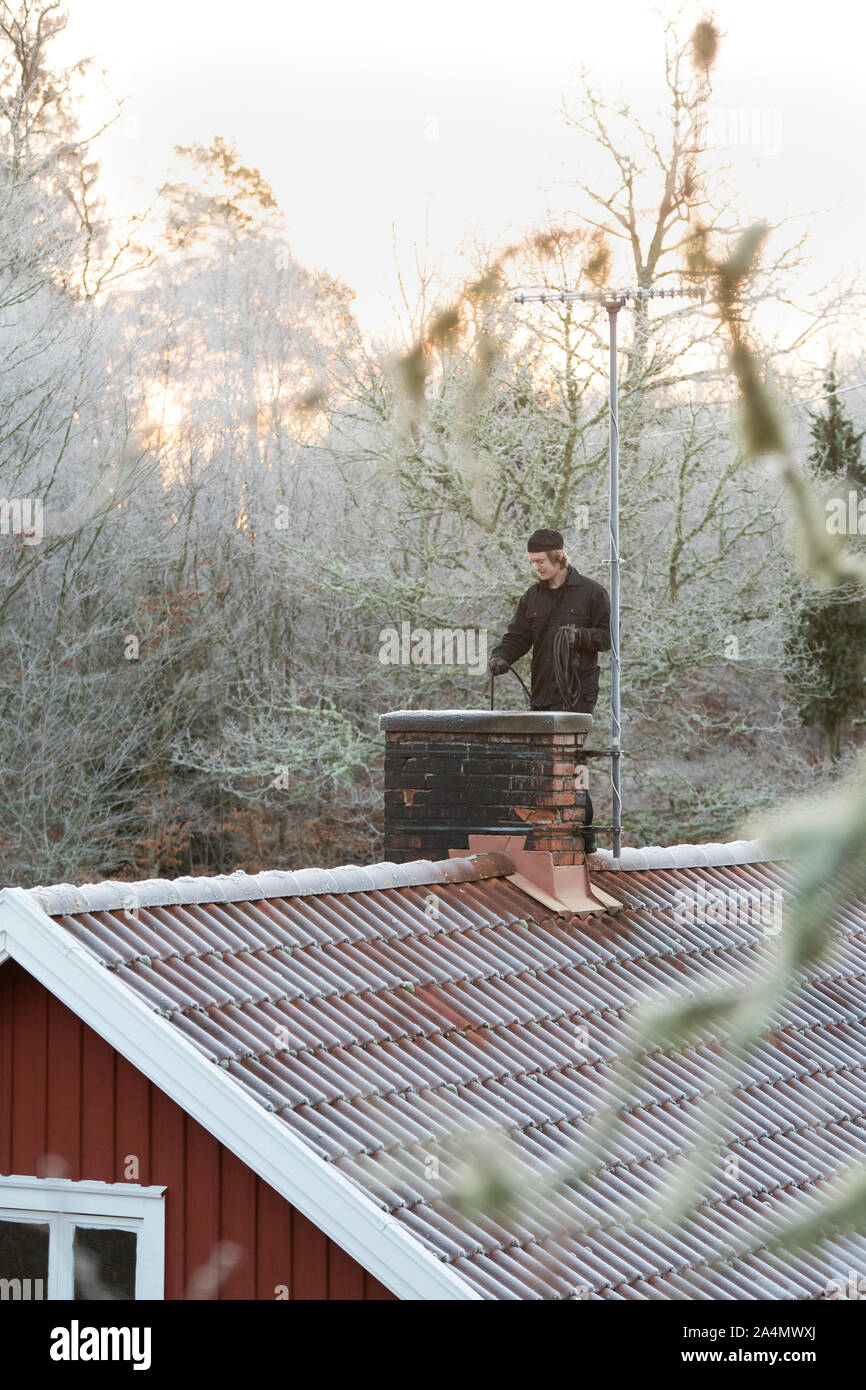 Chimney Sweep cleaning chimney Stock Photo - Alamy