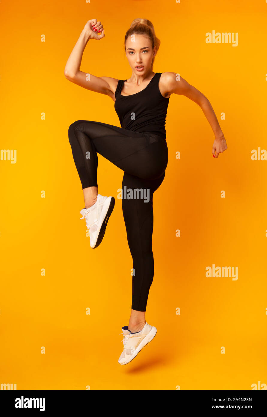 Fitness Woman Jumping While Exercising On Yellow Background, Studio ...