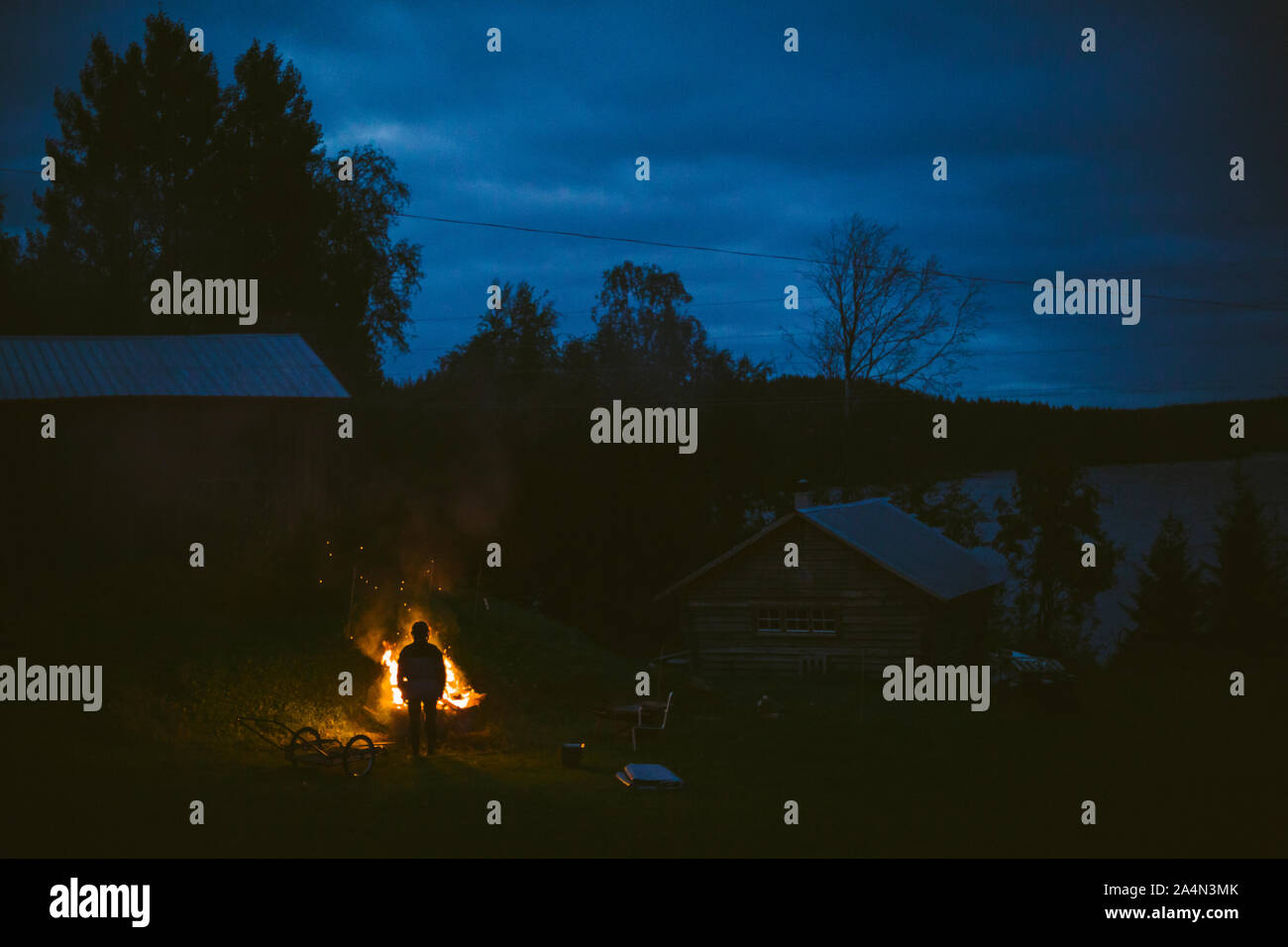 Silhouette of person looking at log fire Stock Photo - Alamy