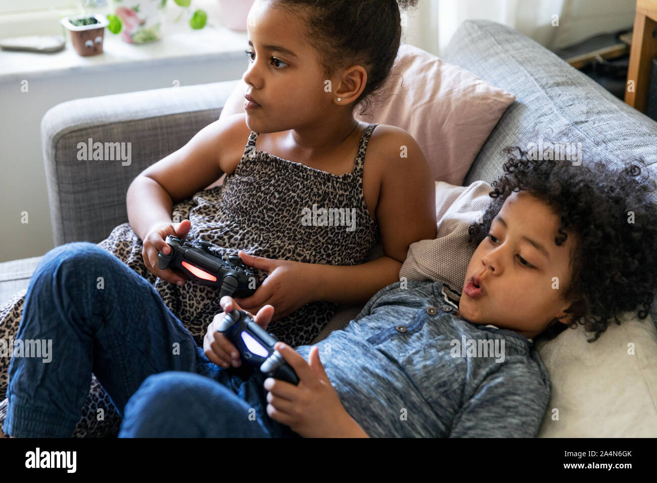 Brother and sister playing video game Stock Photo - Alamy