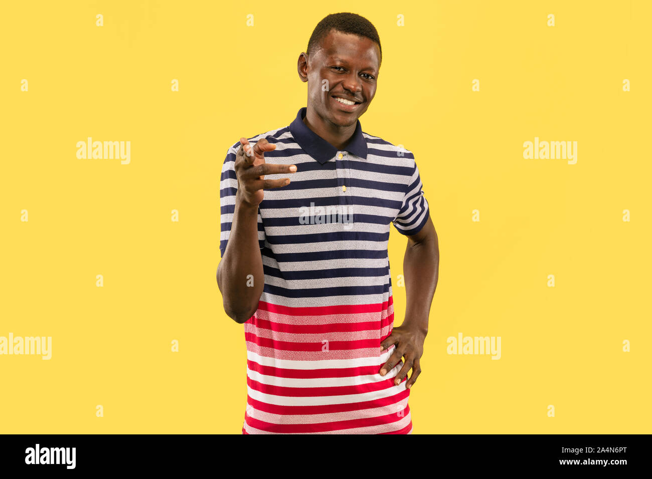 Point at you. Young african-american man isolated on yellow studio ...