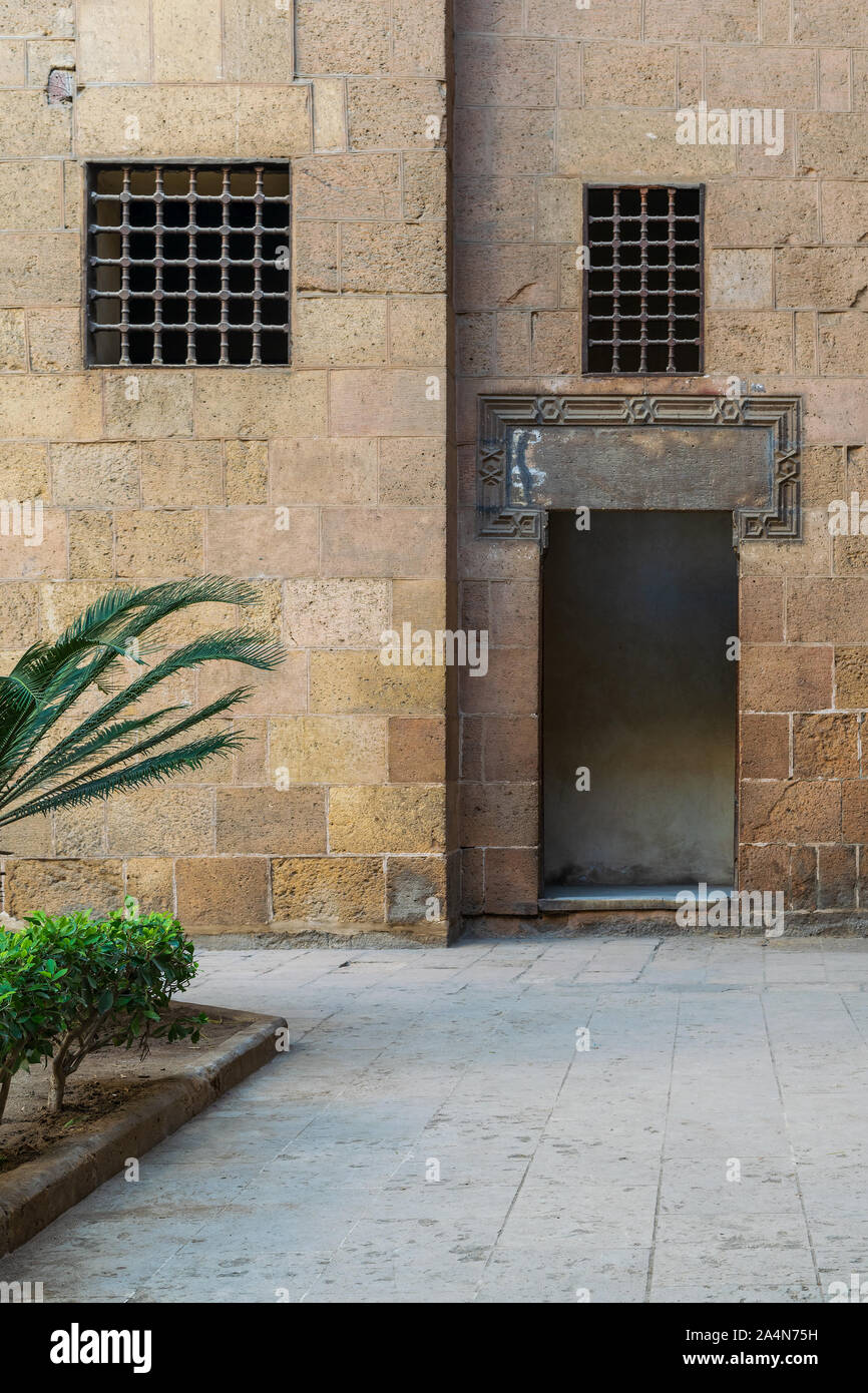 Ancient external old decorated bricks stone wall with two windows and ...