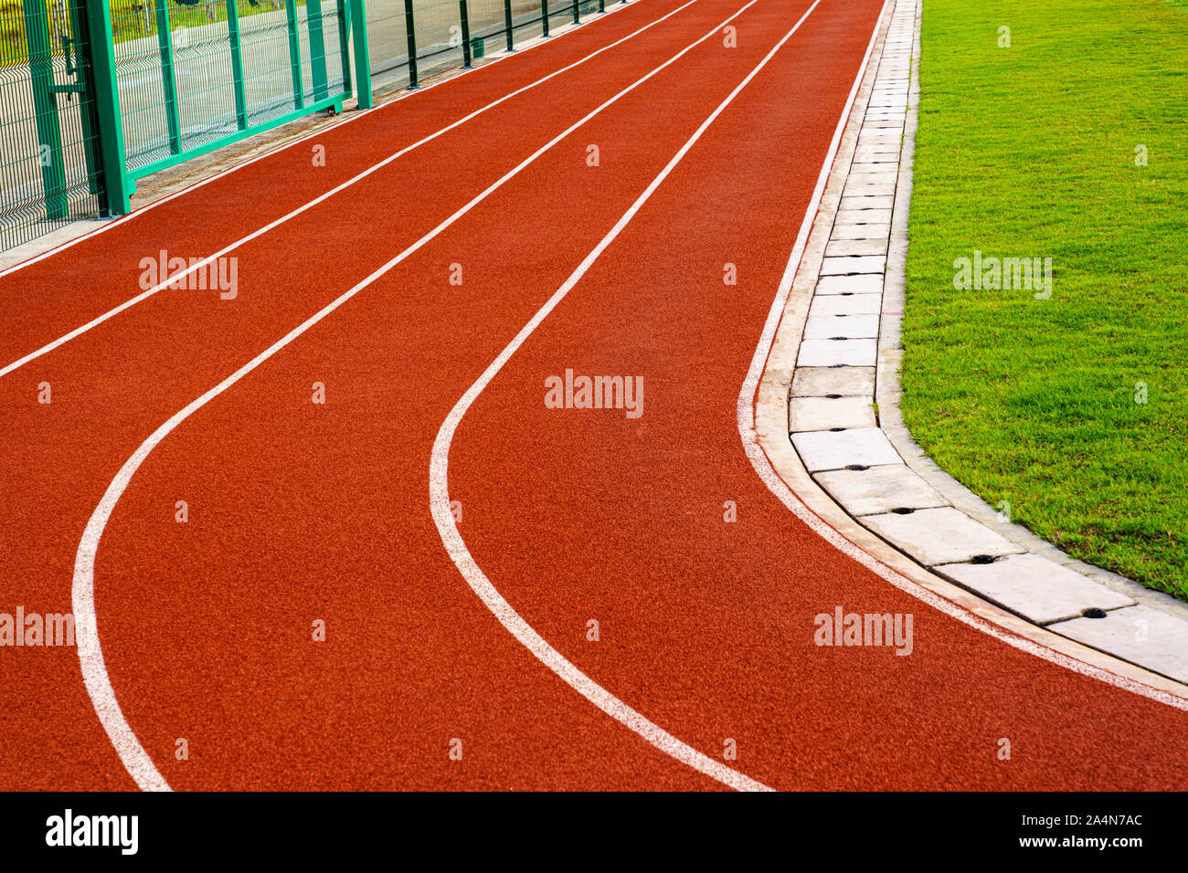 Red running track with white lines in outdoor sport stadium, side is a ...