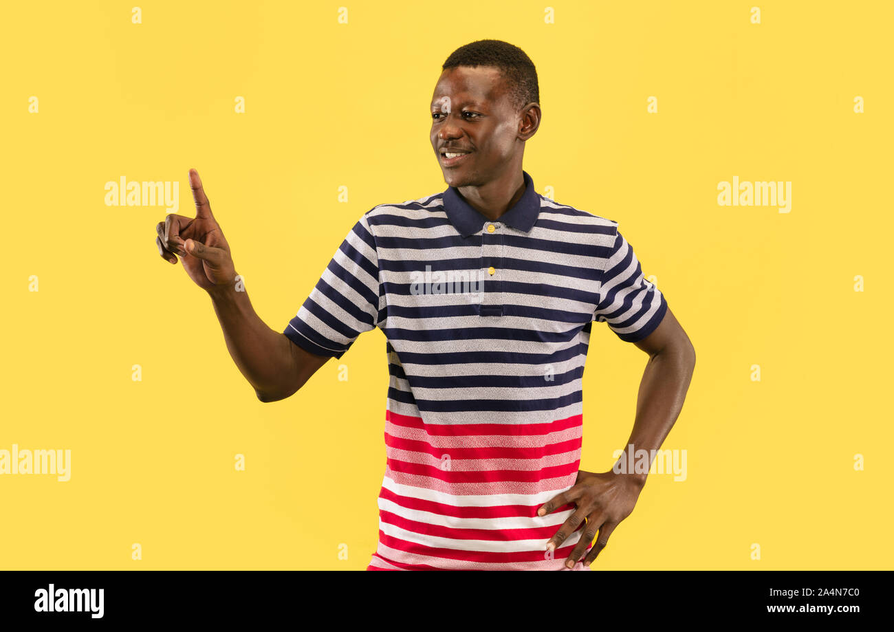 Point at you. Young african-american man isolated on yellow studio ...