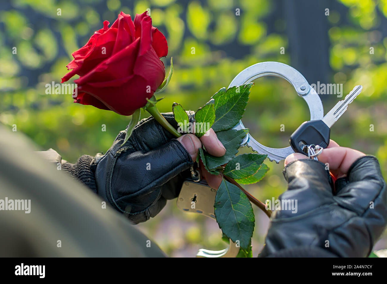 outdoors, close up, the hand of a man in leather gloves and handcuffs ...