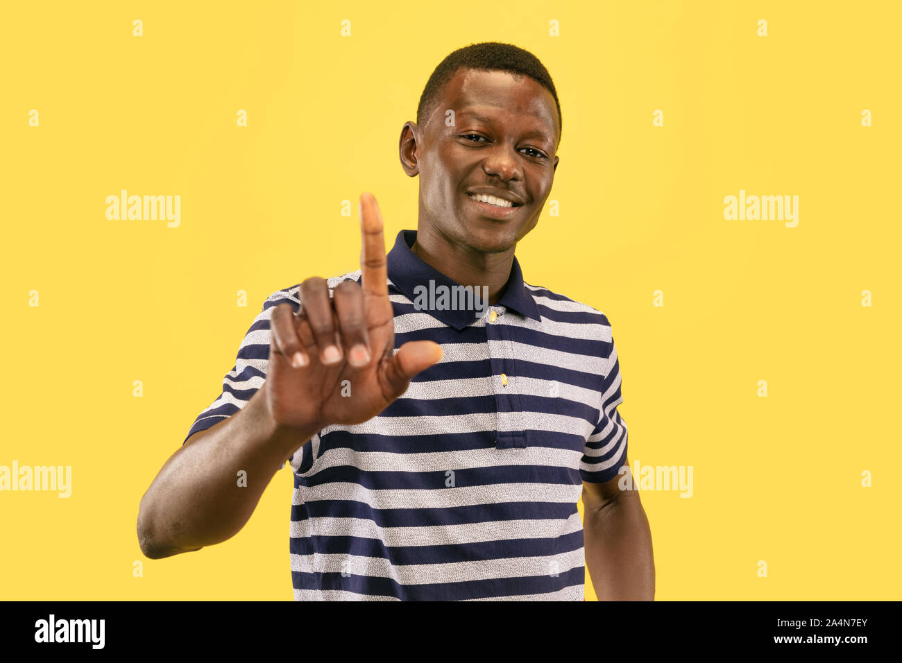 Point at you. Young african-american man isolated on yellow studio ...