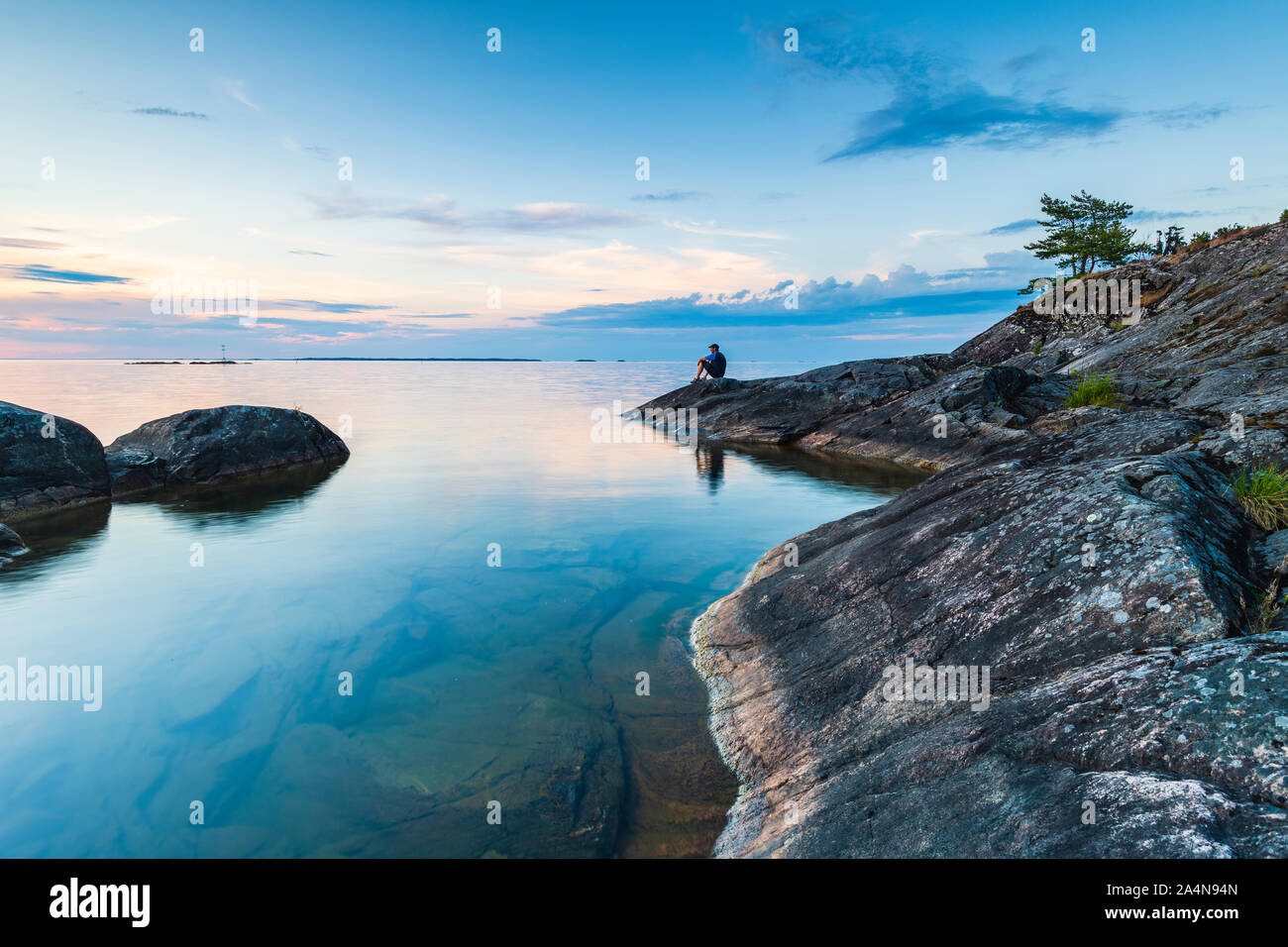 Man sitting on rocks Stock Photo - Alamy