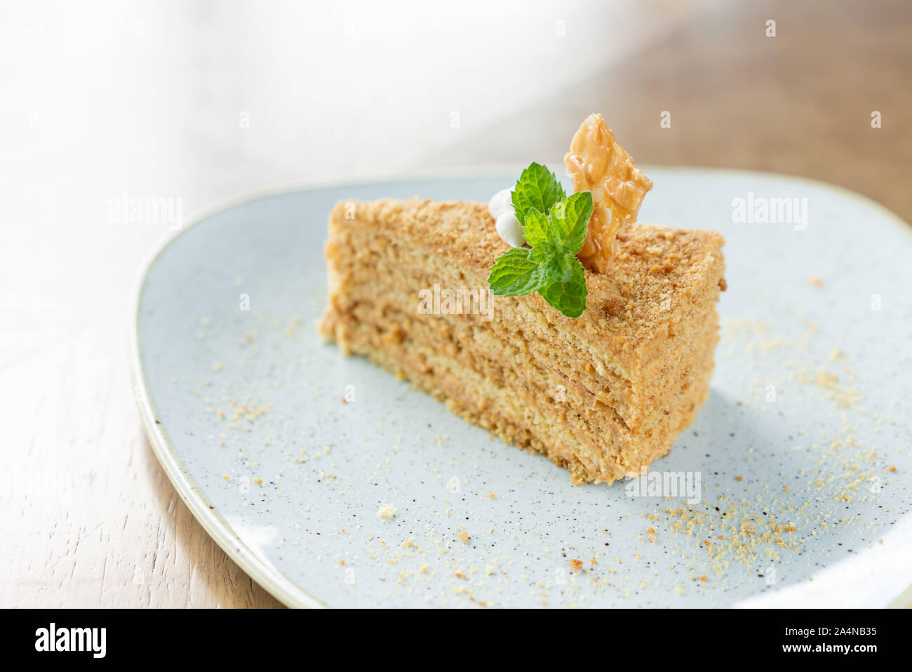 Honey sponge cake decorated with meringue and mint leaves. Breakfast in ...