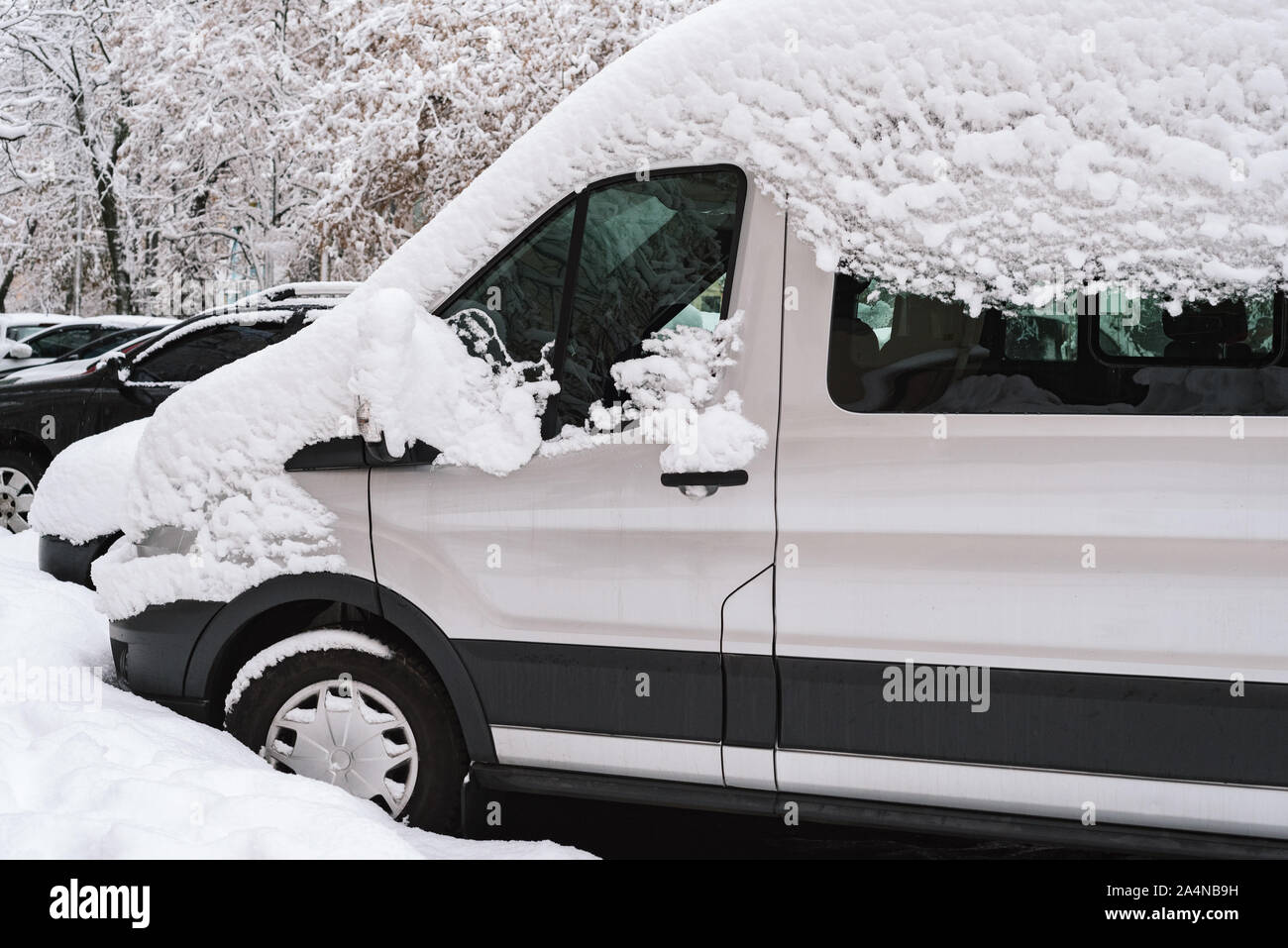 First snowfall. Snow-covered cars after a sudden snowfall. Winter in ...