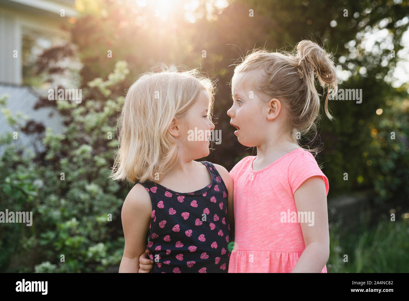 Two girls standing back to back hi-res stock photography and images - Alamy