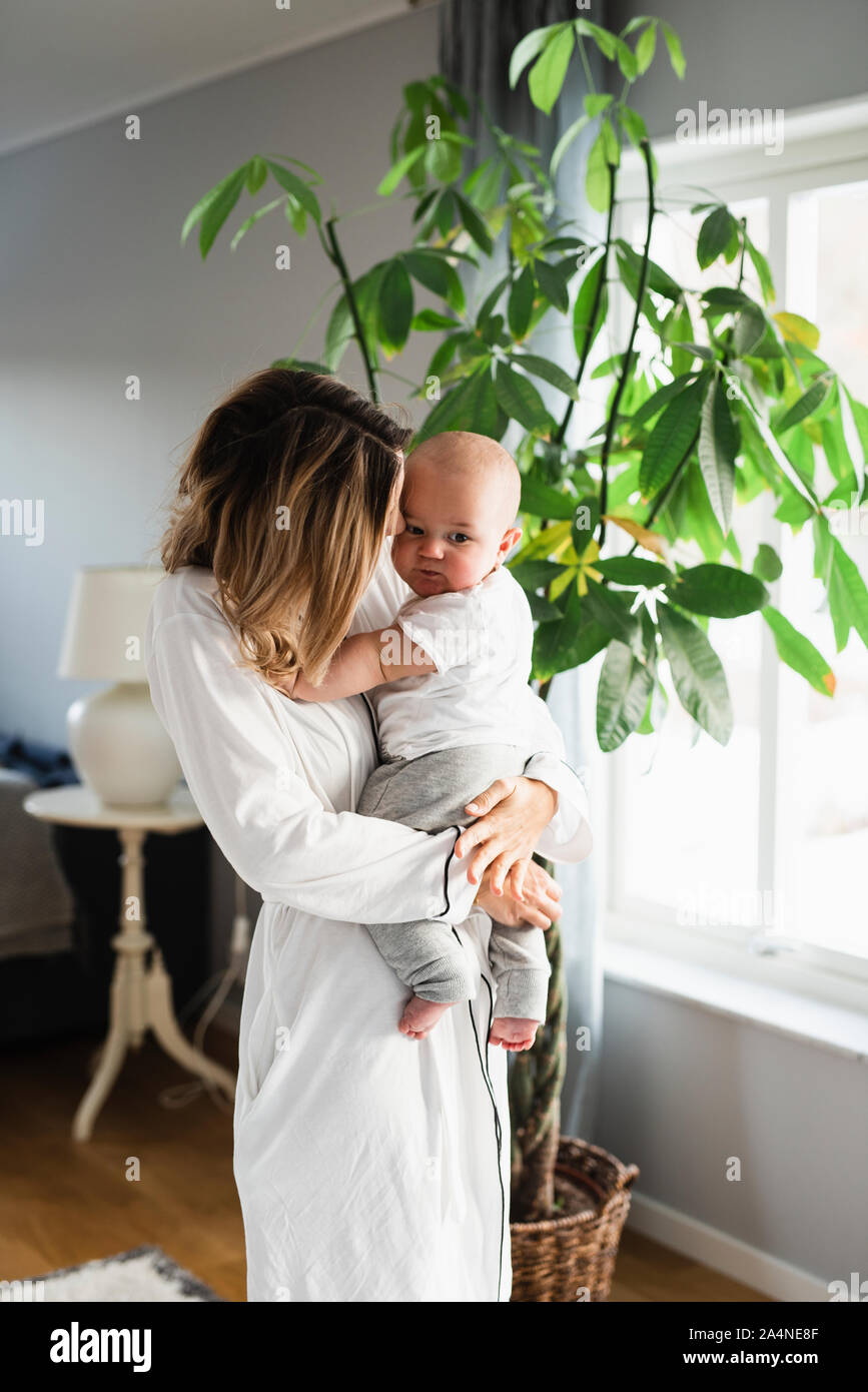 Woman carrying baby boy Stock Photo - Alamy