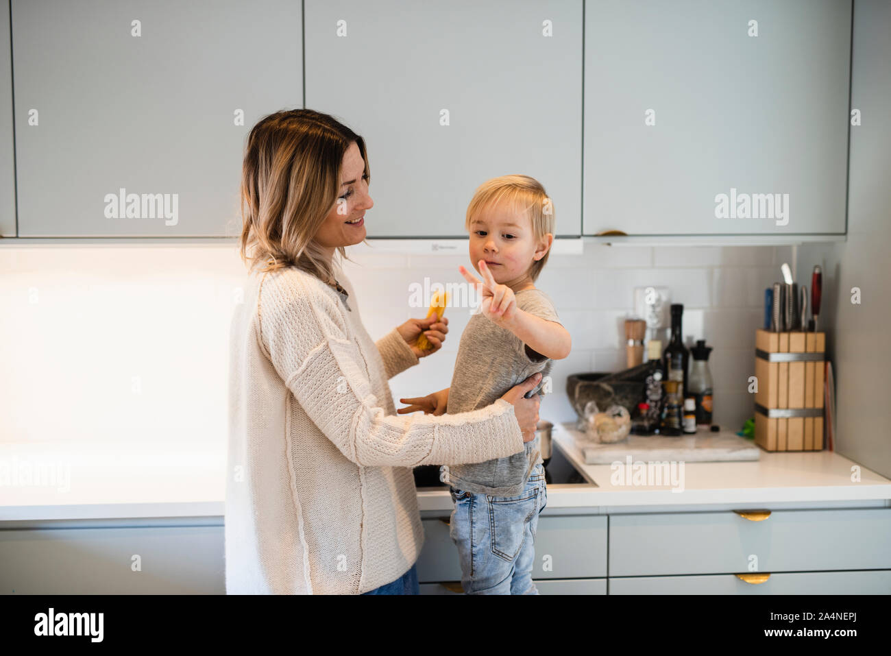Woman carrying boy Stock Photo - Alamy