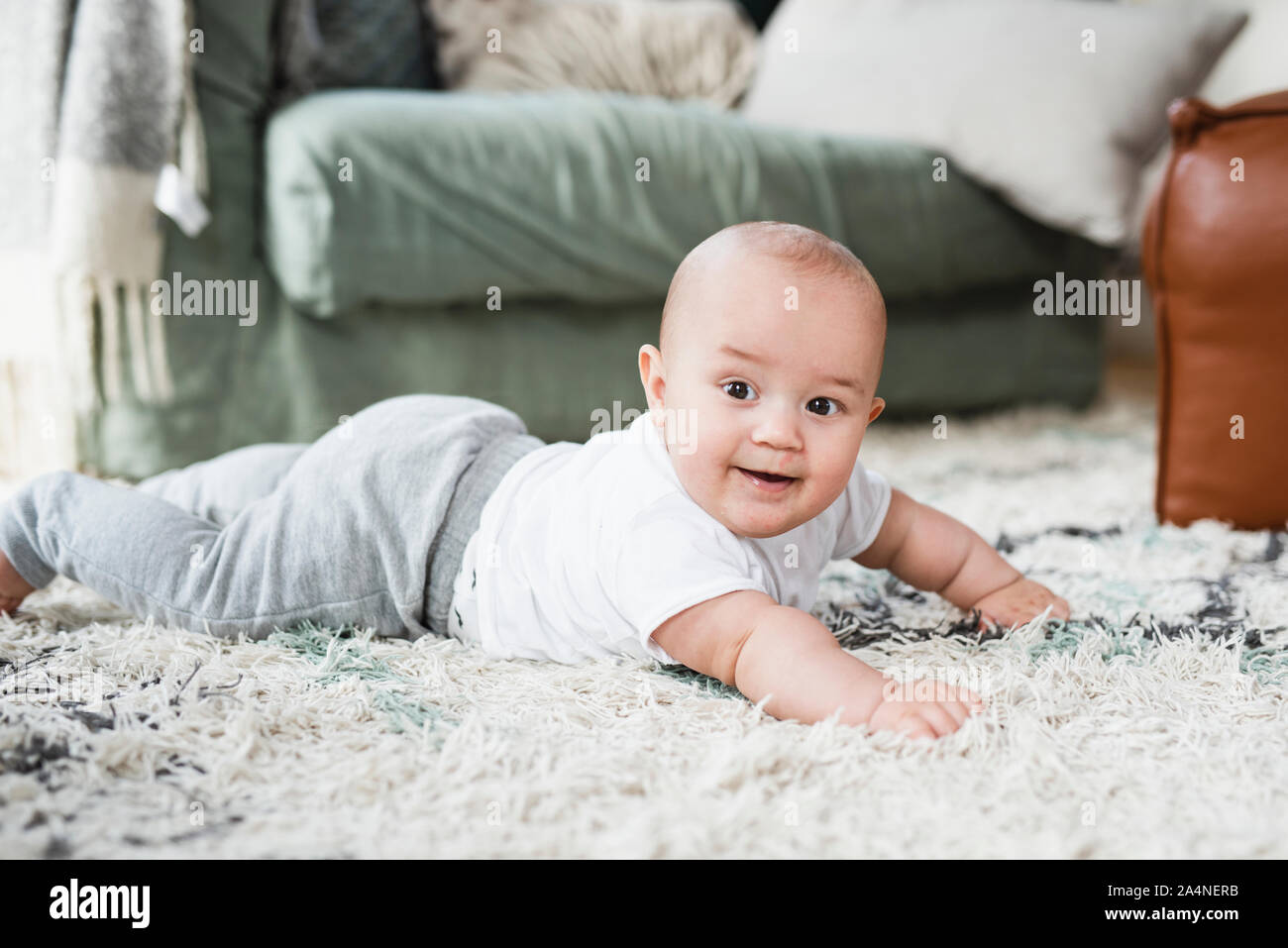 Baby boy lying on carpet Stock Photo - Alamy