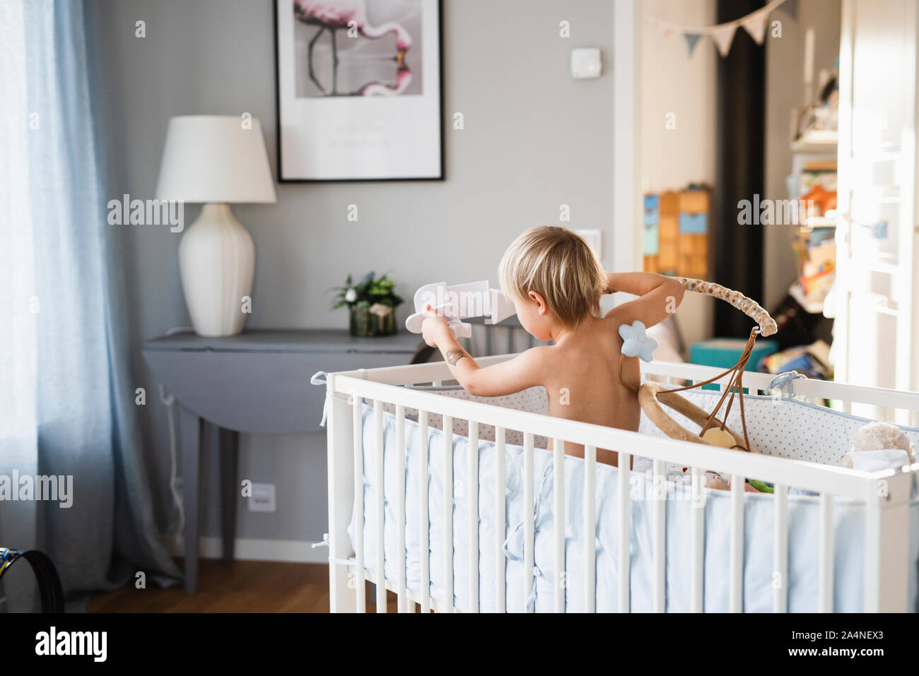 Boy playing in cot Stock Photo - Alamy