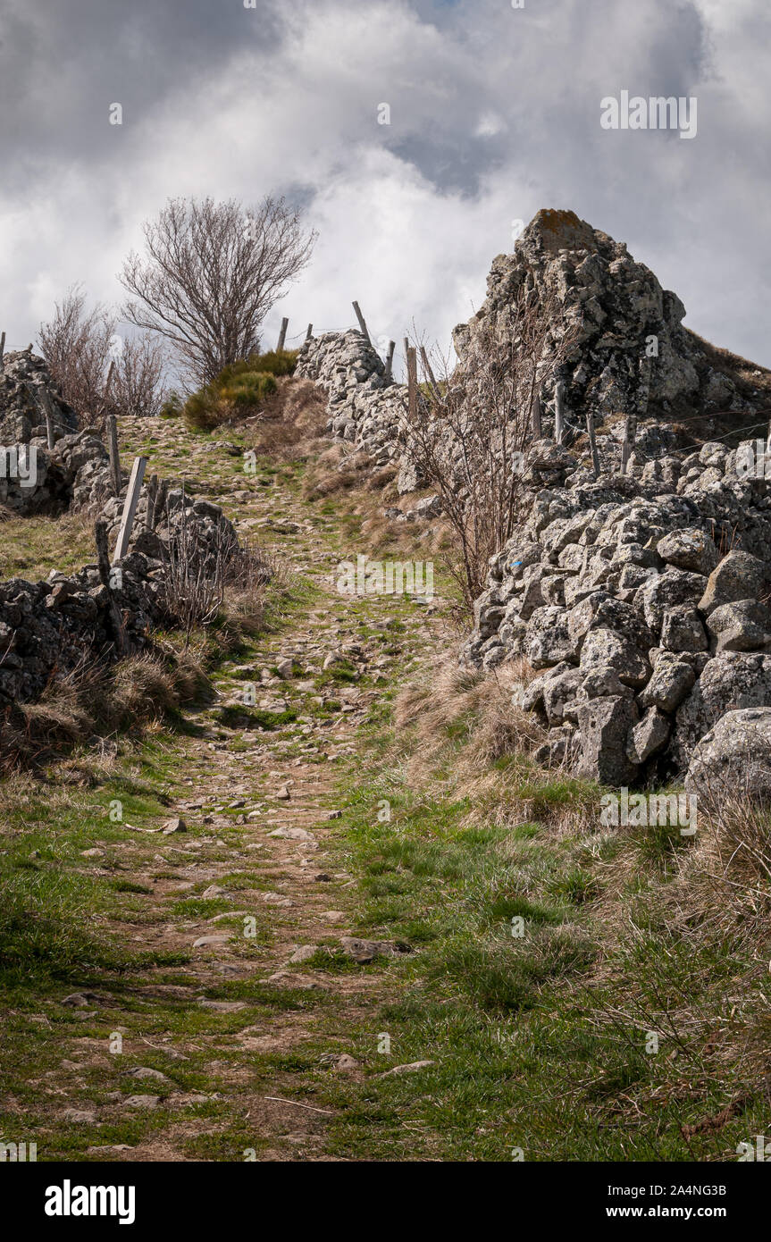 stony Pathway or footpath leading up hill towards a cloudy sky ,with ...