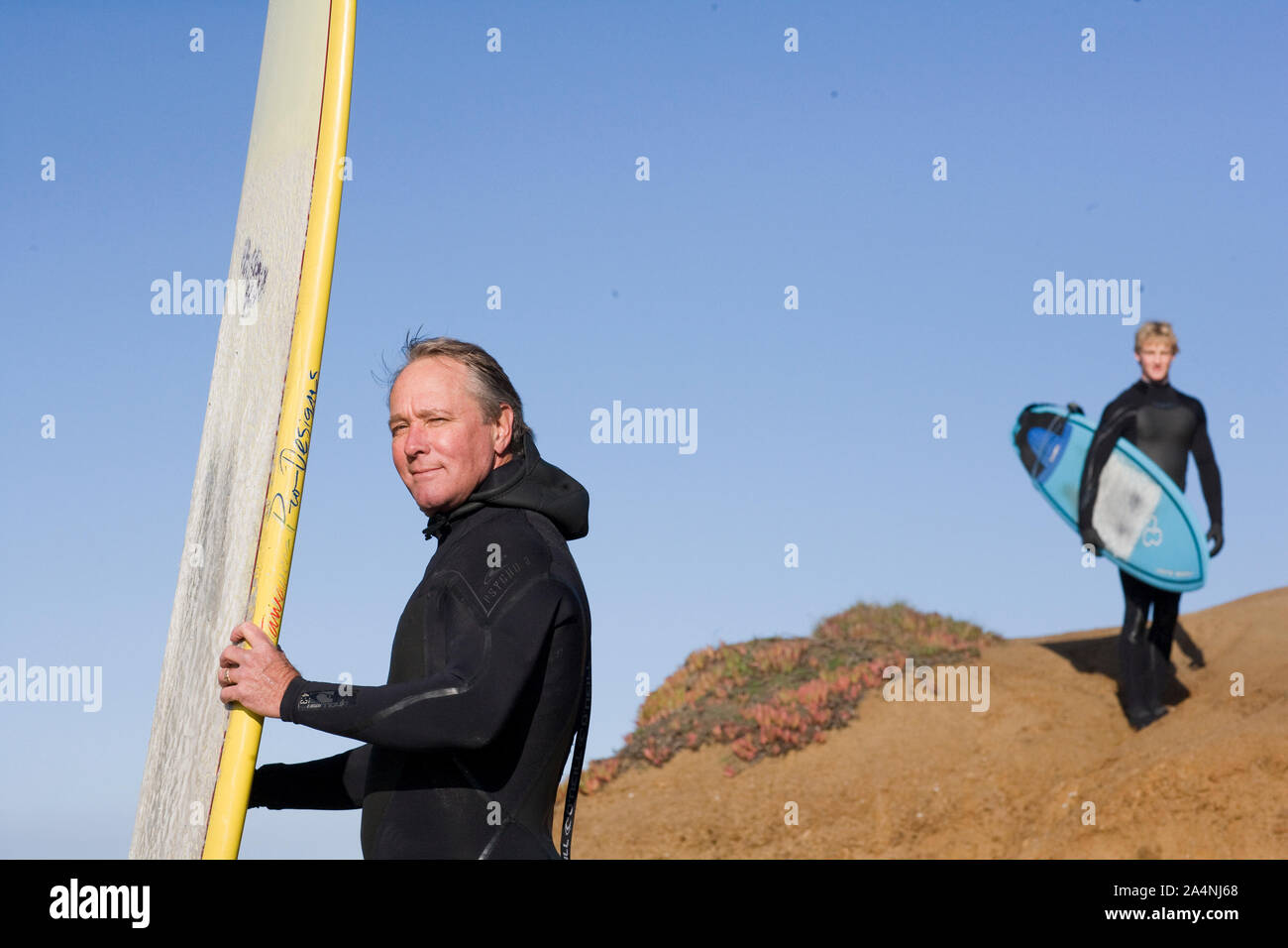 Father and son carrying surfboards on the beach Stock Photo - Alamy