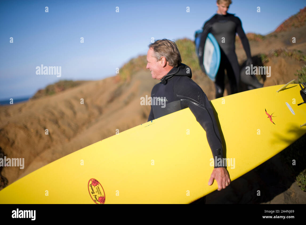 Father and son carrying surfboards Stock Photo - Alamy