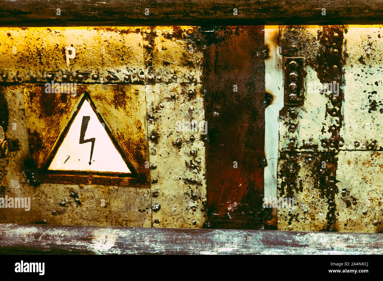 Sign of high voltage, glued on a rusty metalic background with rivets ...