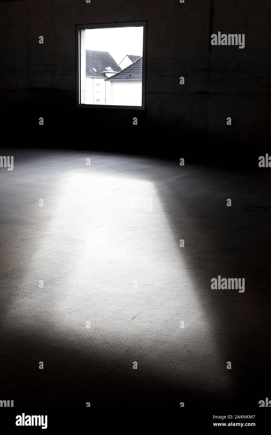 Light falls through a square window into a large, empty room Stock ...
