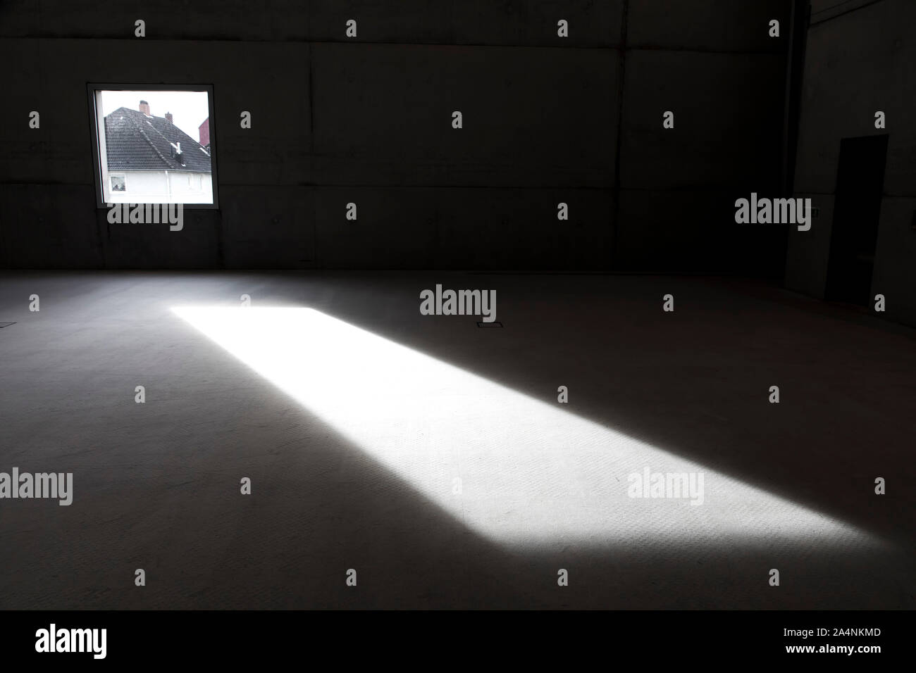 Light falls through a square window into a large, empty room Stock ...
