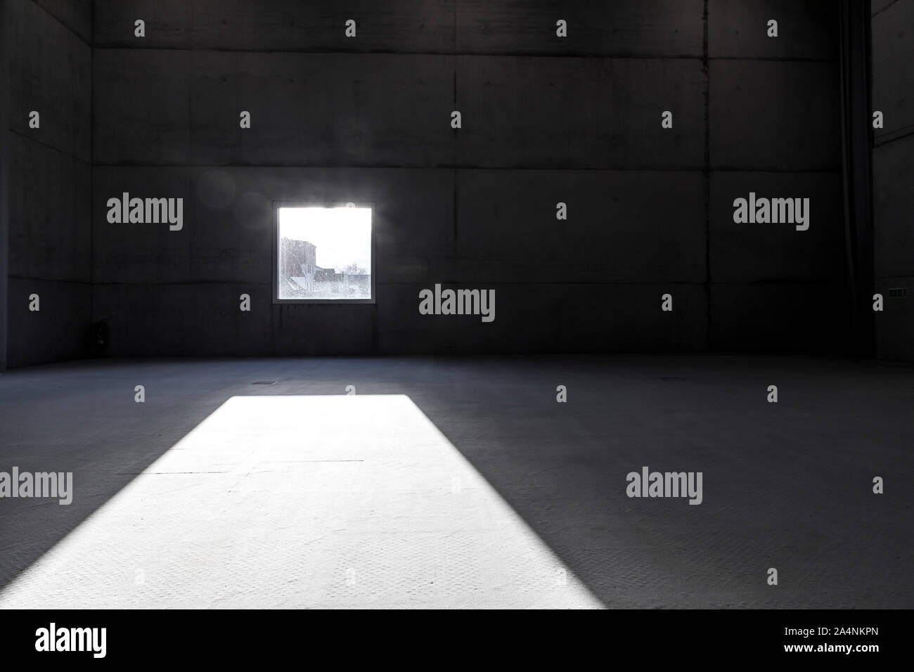 Light falls through a square window into a large, empty room Stock ...