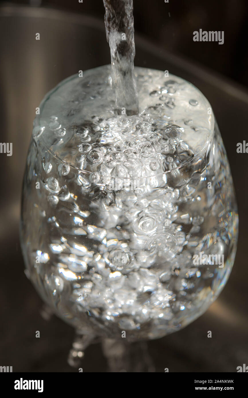 Water flows from a tap into a glass. Symbol: water consumption, waste ...